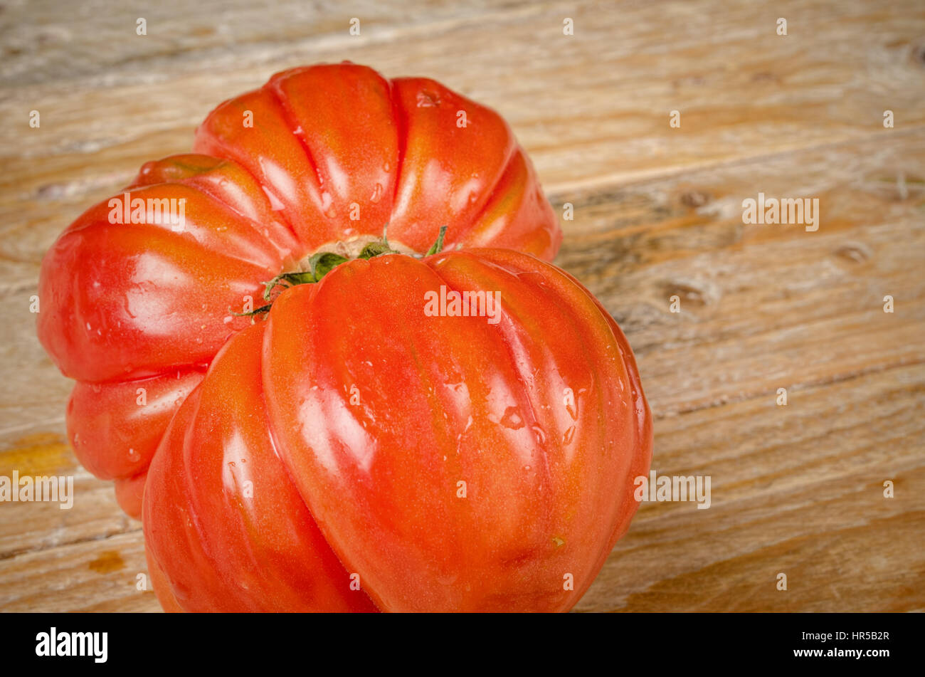 Wrinkled tomato of the particularly tasty Raf type on a rustic wooden ...