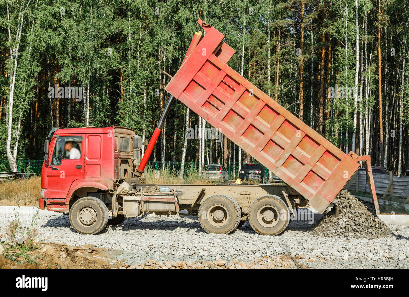 Tipper working outside on road construction in summer Stock Photo - Alamy