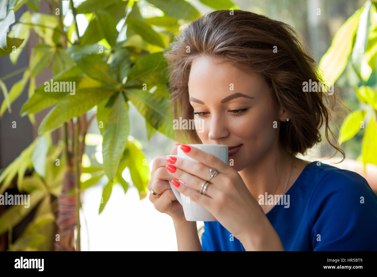 Beautiful young woman drinking coffe in a coffee shop. Beautiful young ...