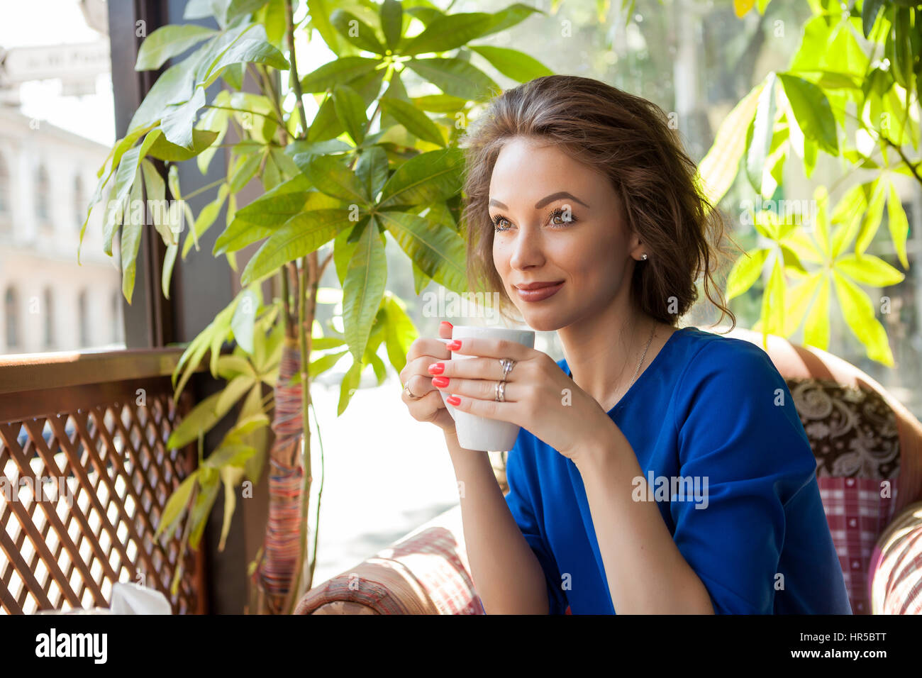 Beautiful young woman drinking coffe in a coffee shop. Beautiful young ...