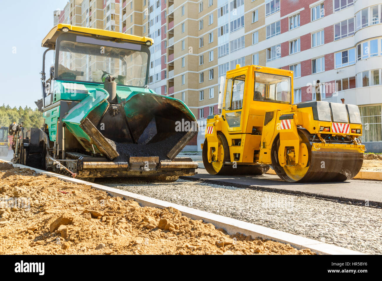 Asphalt-placing machine working on the city road Stock Photo - Alamy