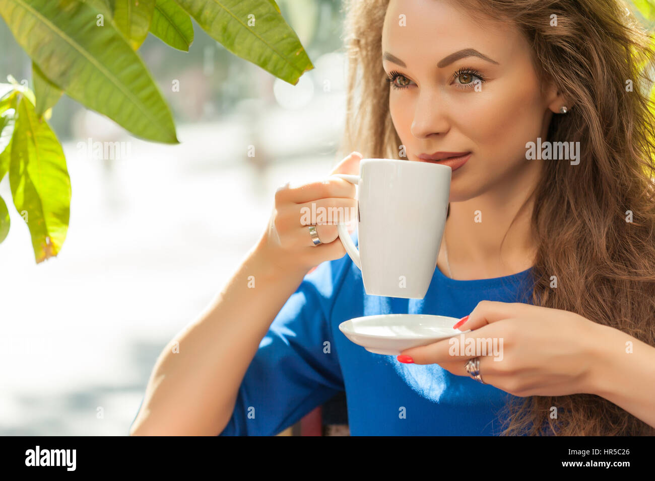 Attractive young woman drinking coffe in a coffee shop. Beautiful young ...
