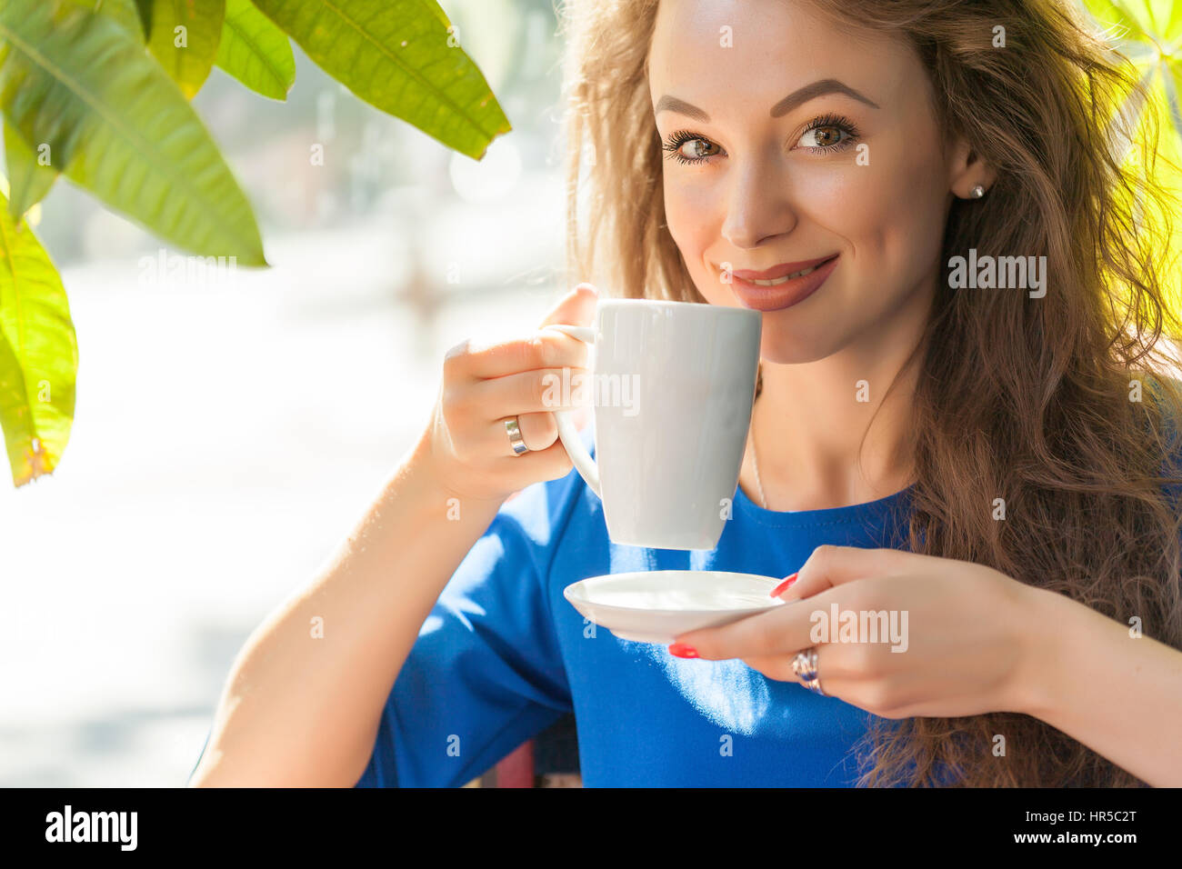 Attractive young woman drinking coffe in a coffee shop. Beautiful young ...