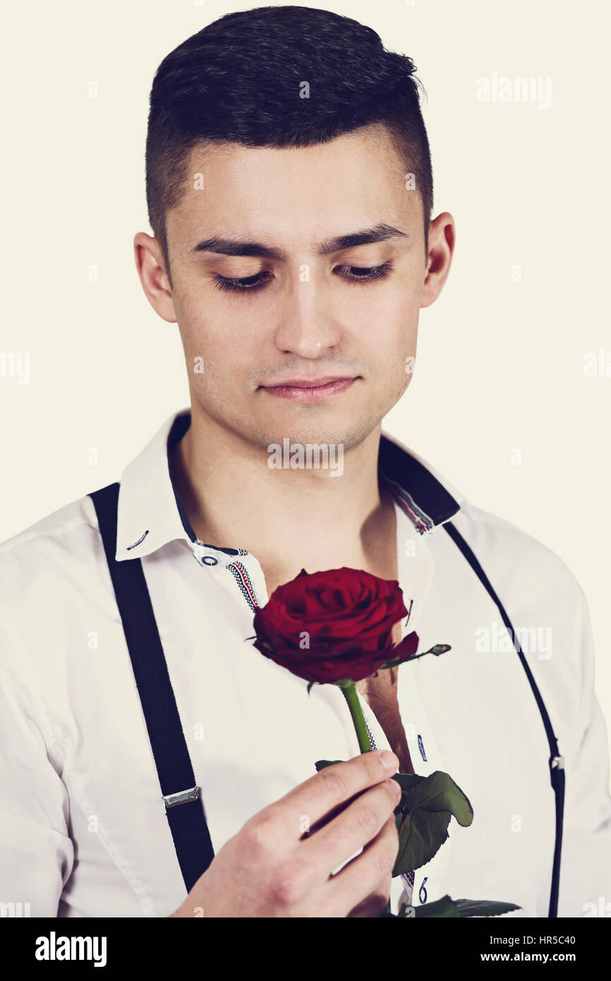 A man with red rose in the hands. Valentine day Stock Photo - Alamy