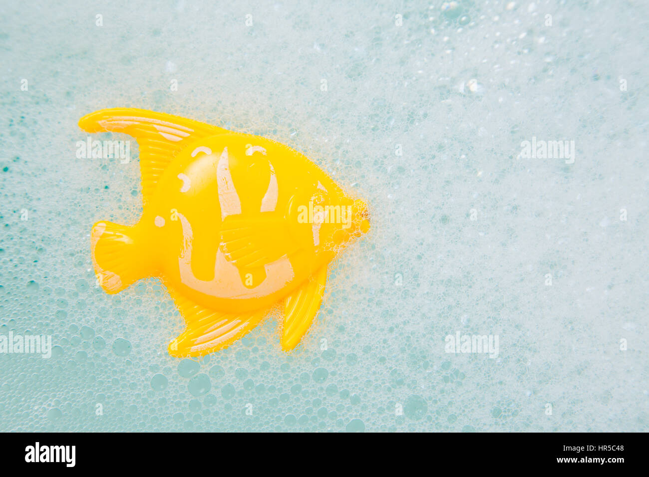 Bath toy fish in white foam bubbles Stock Photo - Alamy