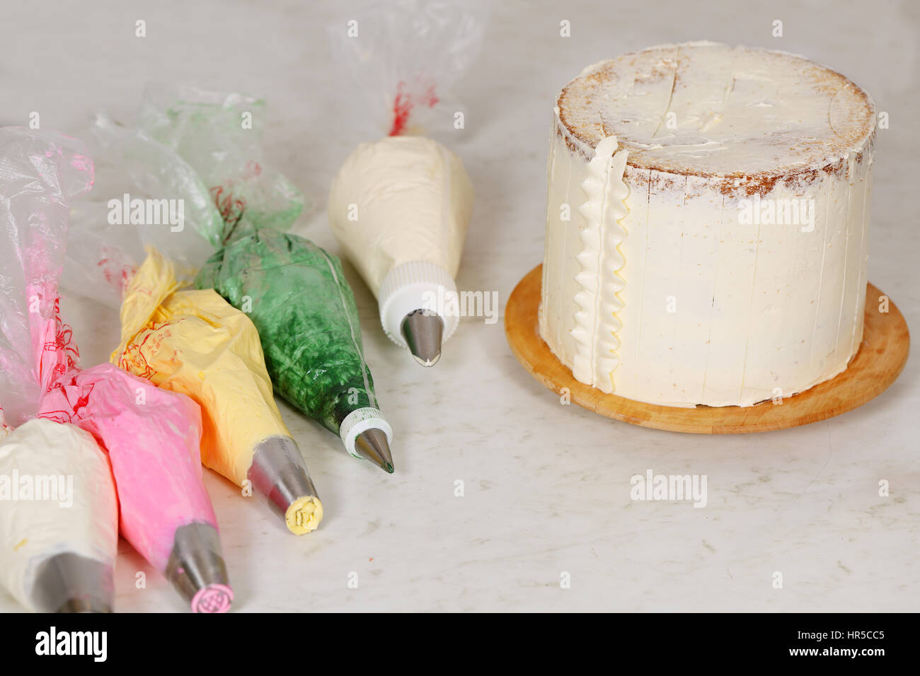 Prepared cake and packets with colored cream Stock Photo - Alamy