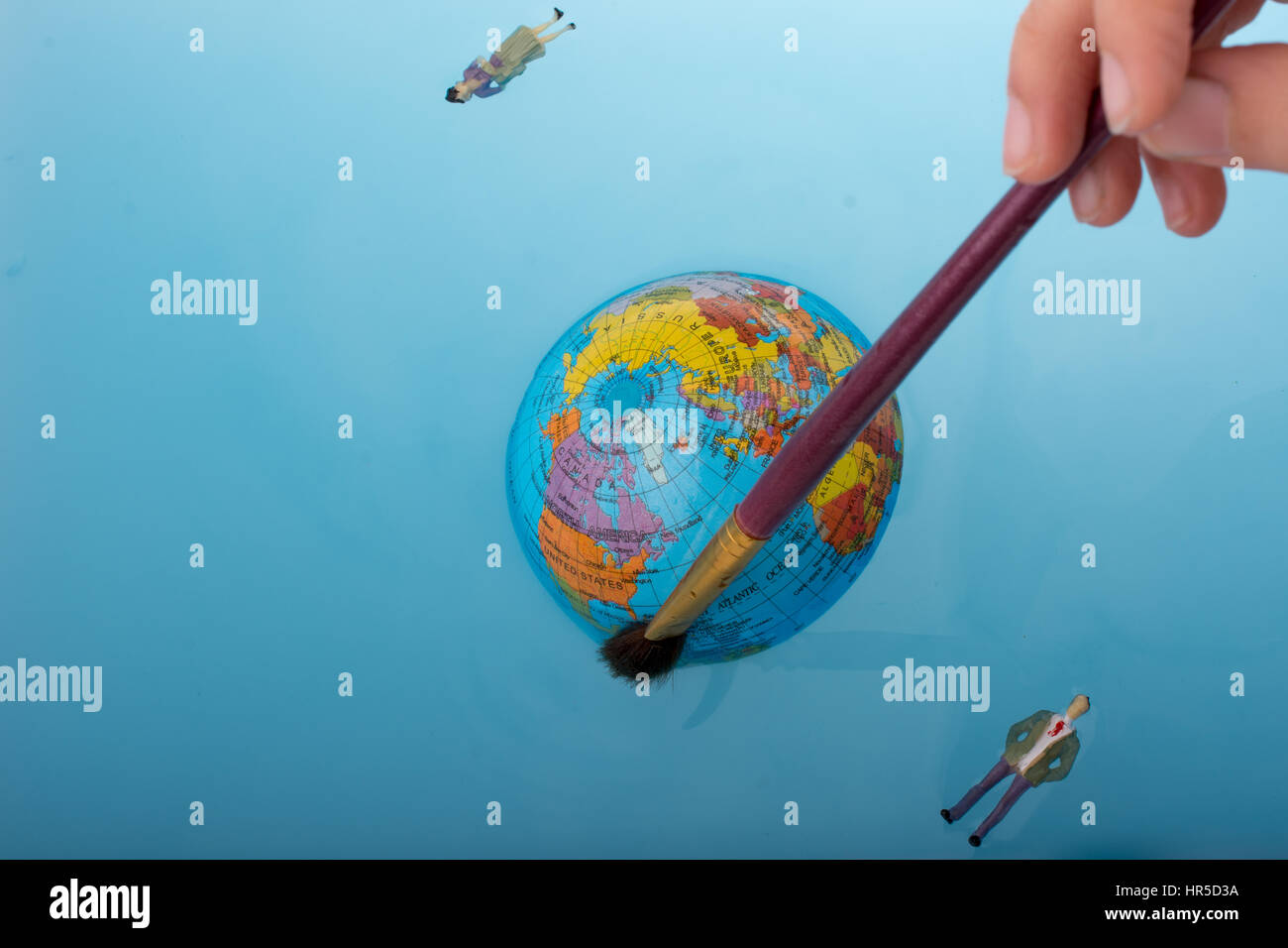Brush and little globe with floating figurines around in water Stock ...