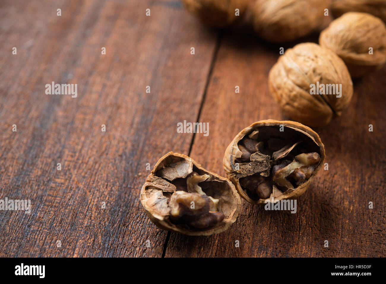 Cracked walnuts shell on wooden table background Stock Photo - Alamy