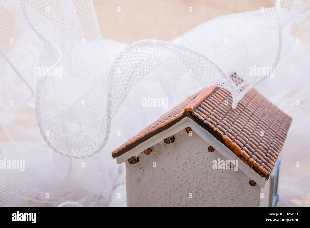 Little model house wrapped in cloth on a brown background Stock Photo ...