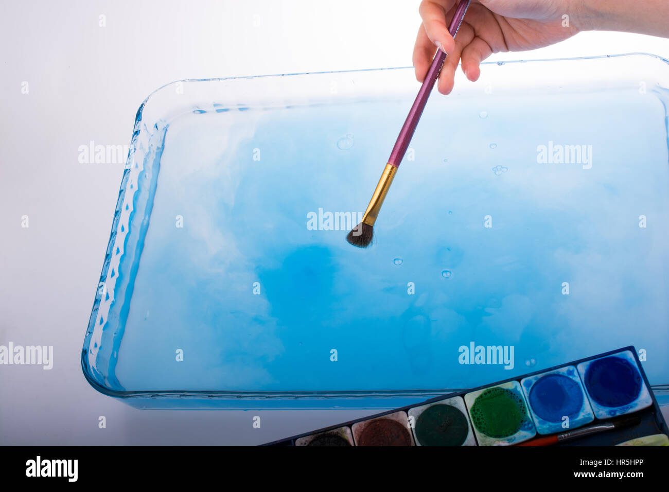 Paint dissolving in water as painting brush touching water Stock Photo ...