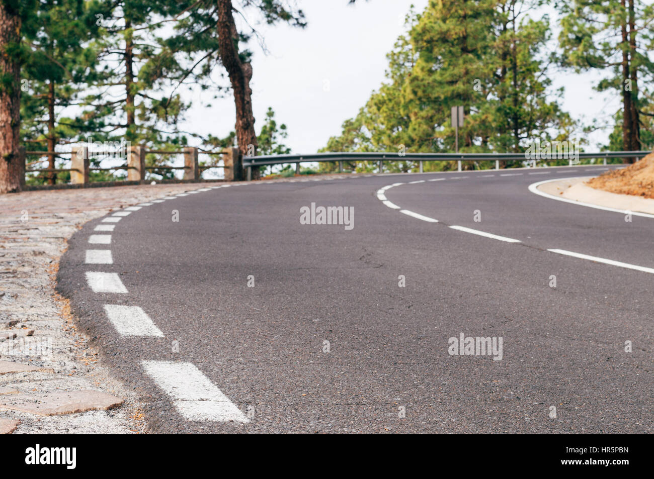 Blurred image of turning road with safety barrier in highland area ...