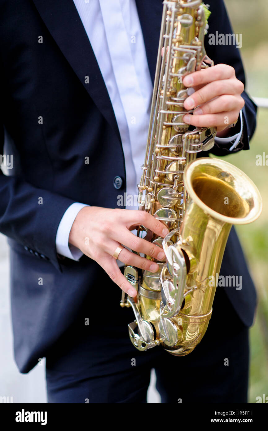 handsome musician in suit is playing saxophone Stock Photo - Alamy