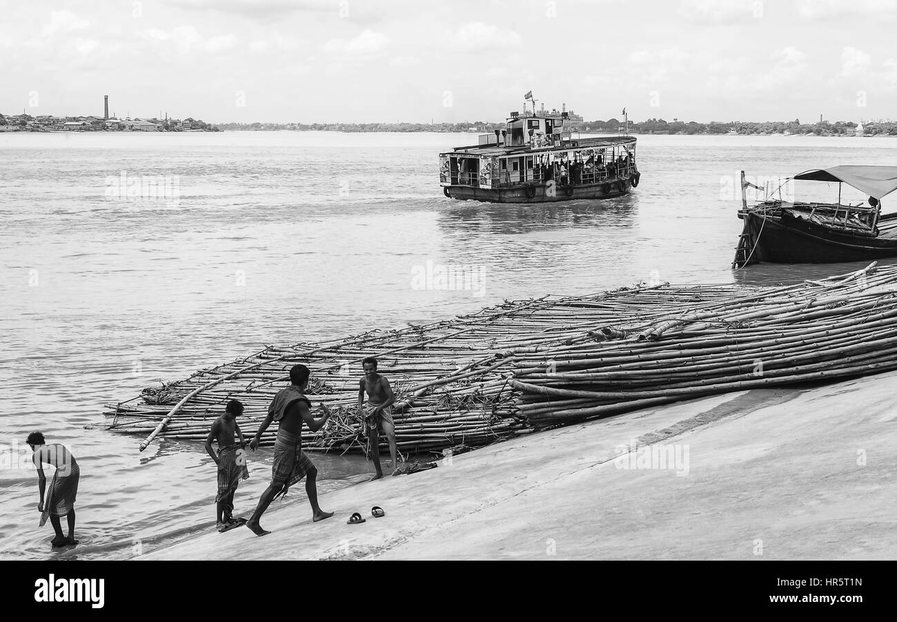People bathe in the Hoogly river as a public ferry transports ...