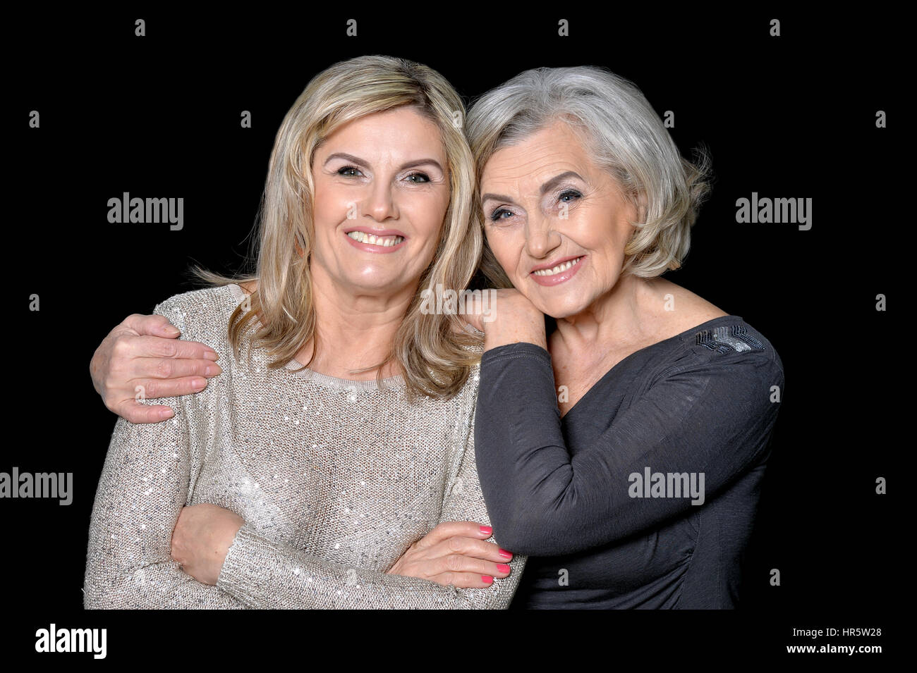 two beautiful senior women posing against black background Stock Photo ...