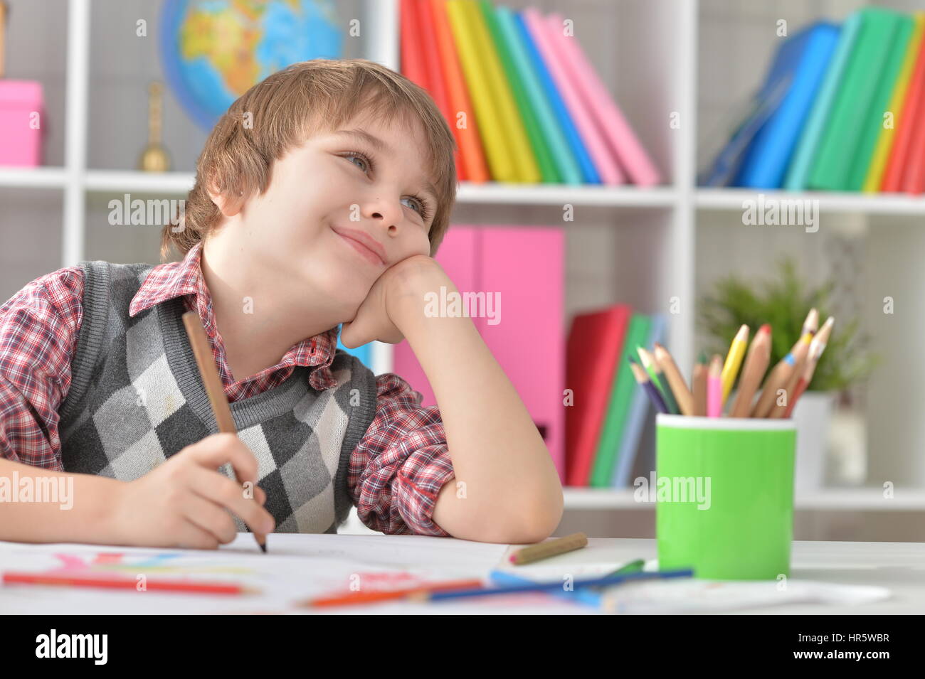 Little boy sitting at table and drawing with colorful pencils Stock ...