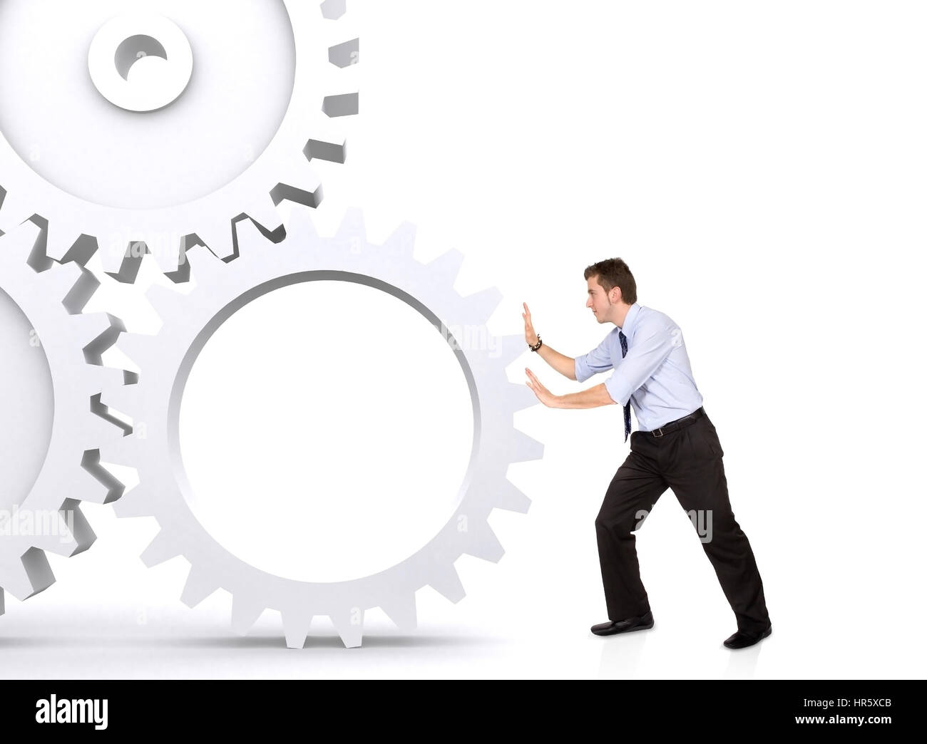 business man pushing a cogwheel to make it work Stock Photo - Alamy