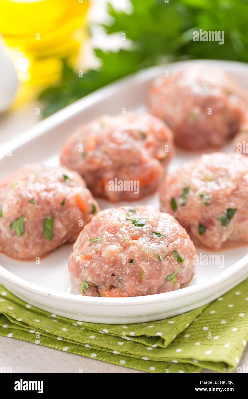 Raw meatballs on white plate, cooking in kitchen Stock Photo - Alamy