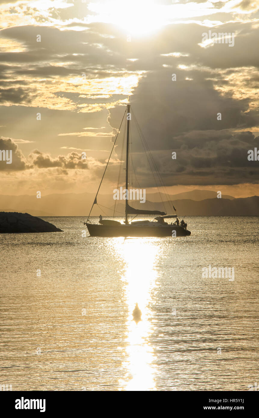 View of sailing boat crossing the sun glitter Stock Photo - Alamy