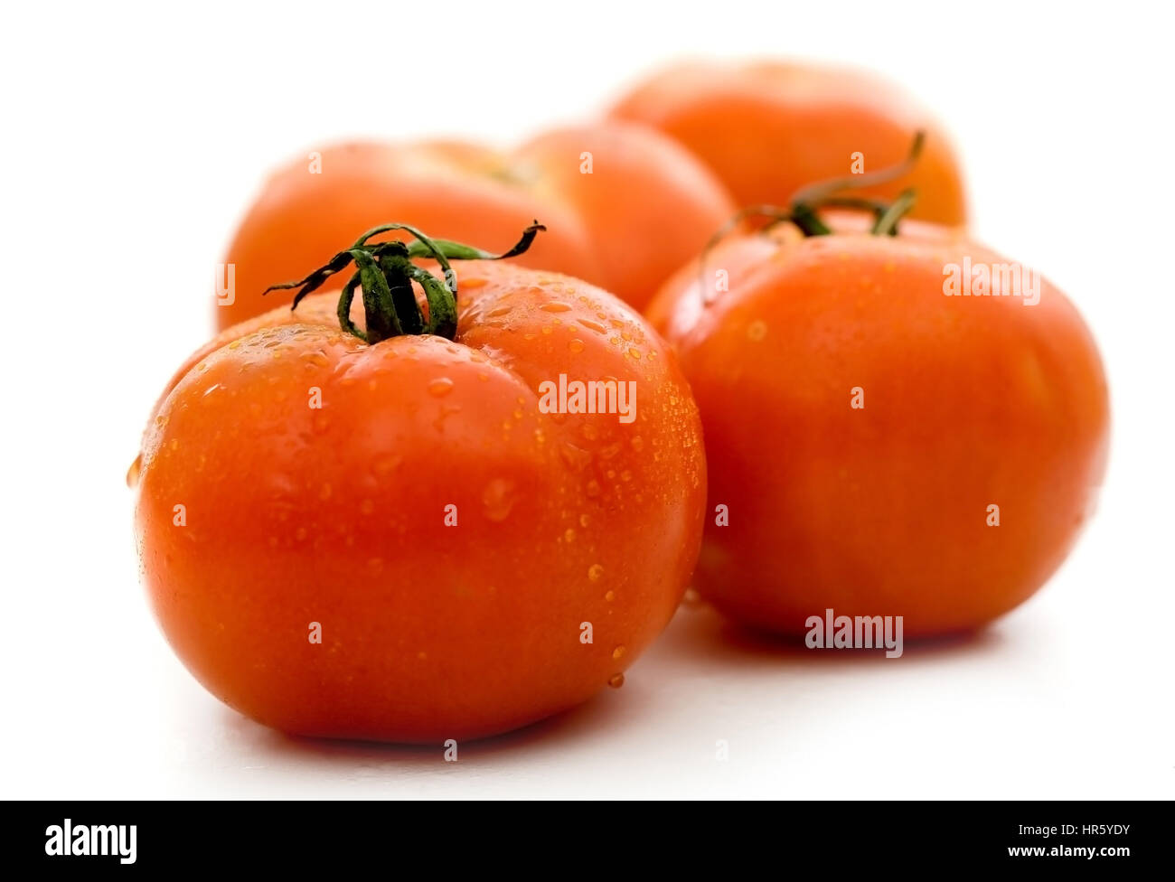 four red tomatoes isolated over a white background Stock Photo - Alamy