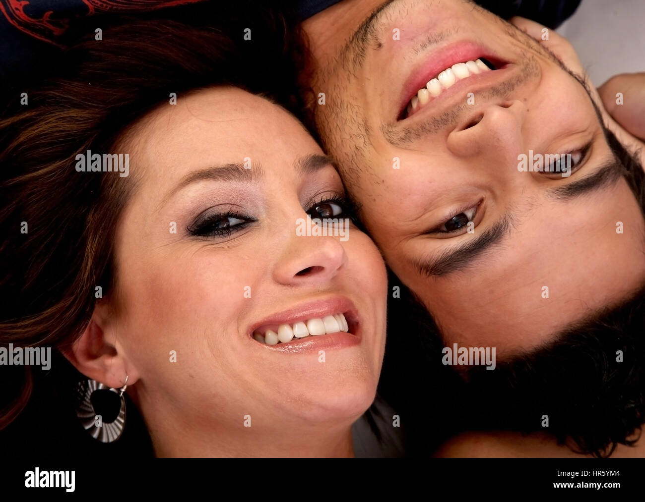 happy couple of lovers on the floor smiling and facing the camera Stock ...