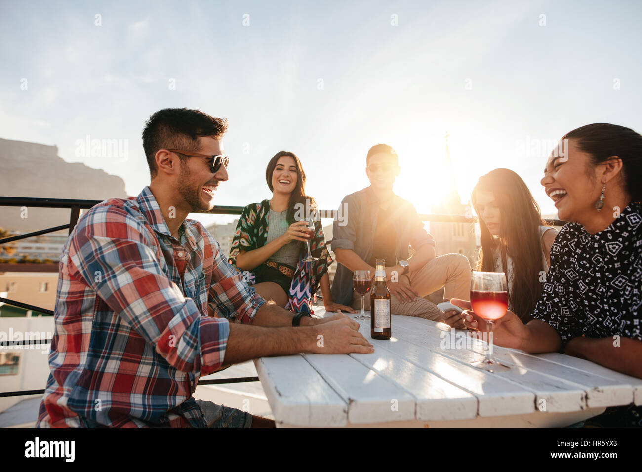 Multiracial group of friends having cocktail party on the rooftop ...