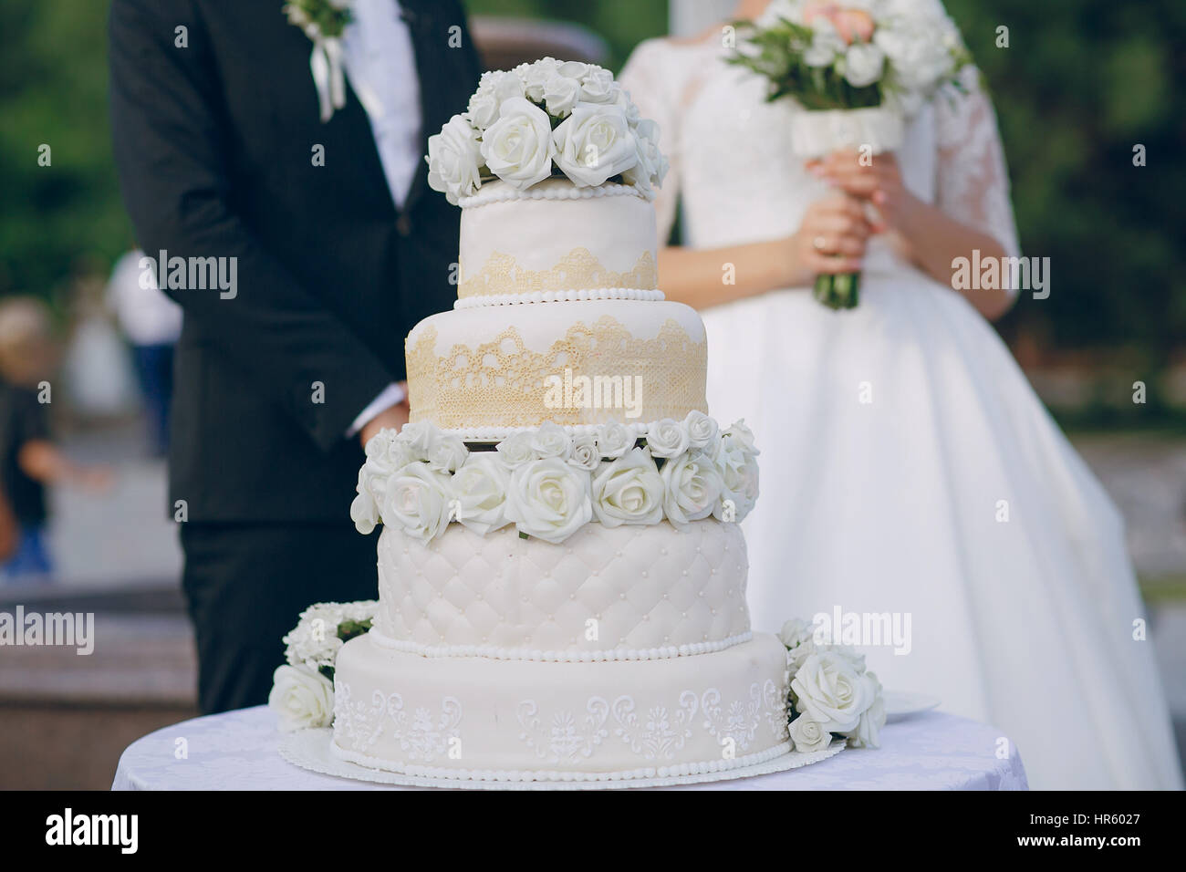 the bride and groom standing near a large wedding cake Stock Photo - Alamy