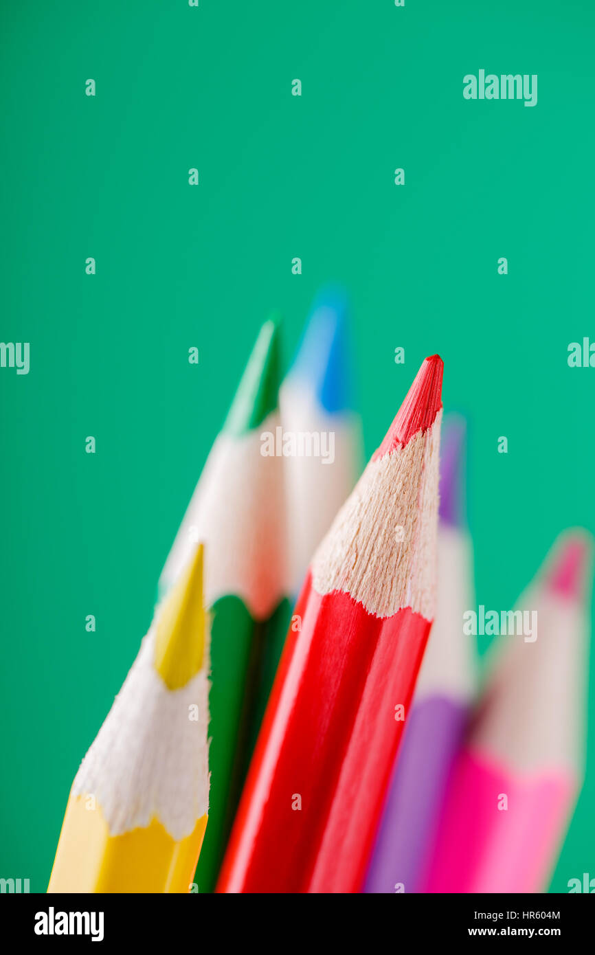 close-up shot of colored pencils standing on the green background Stock ...