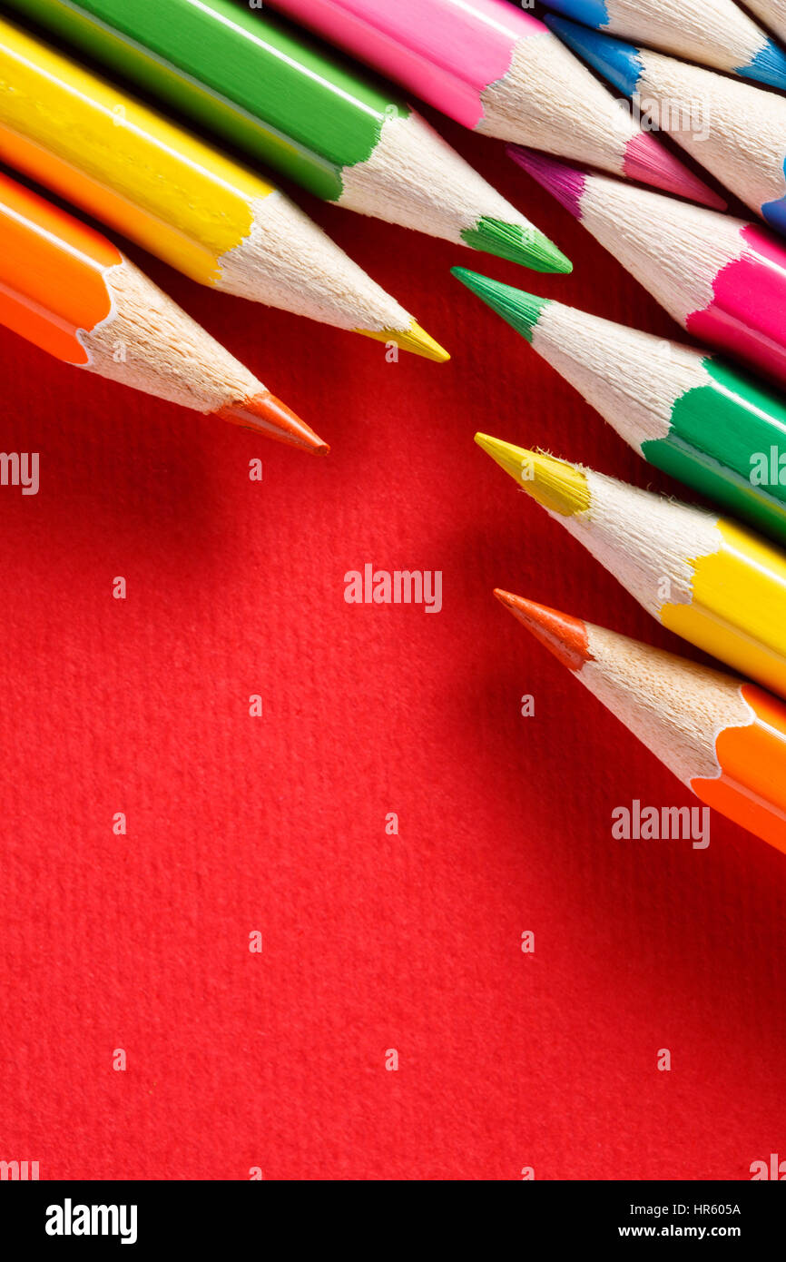 coloring pencils on a red background, angle Stock Photo - Alamy