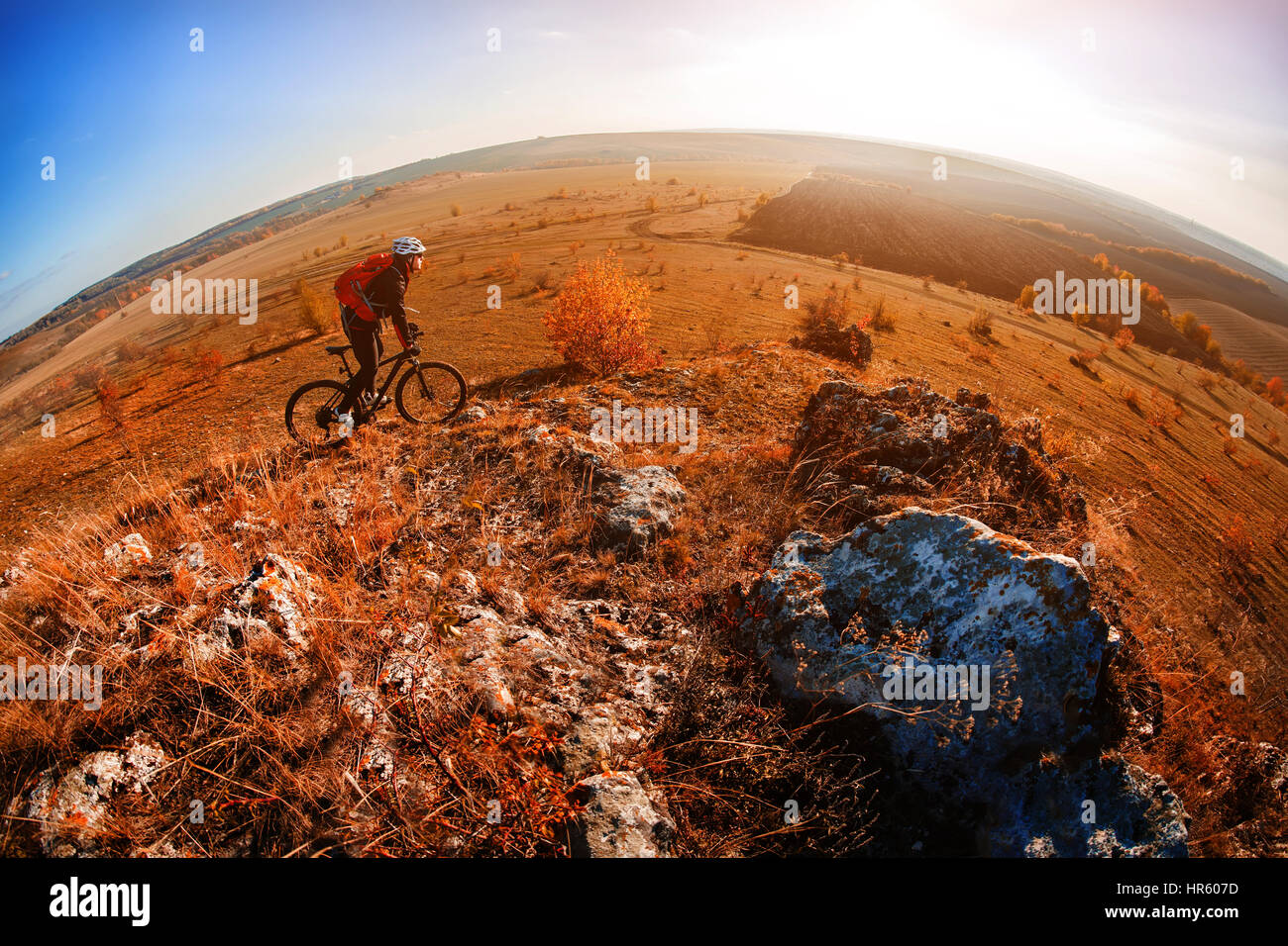 Cyclist riding a bike on an off road to the sunset. Wild landscape ...