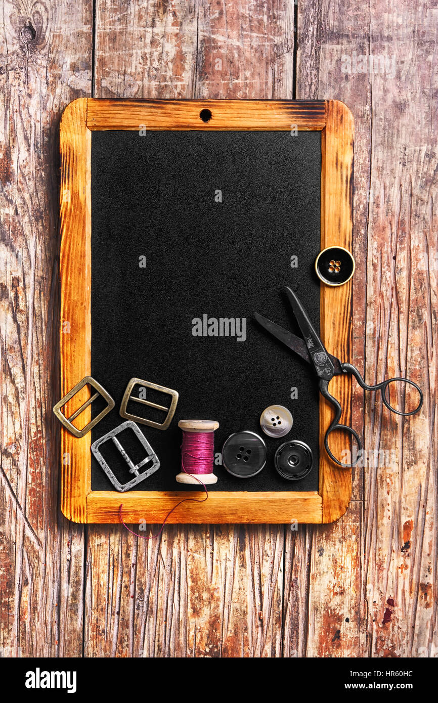 Set of buttons and thread on the chalk board for drawing.Copy space ...