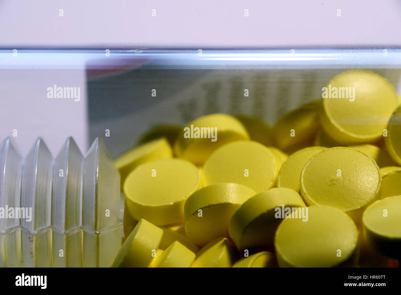 Yellow medical pills in a plastic jar with a screw cap top in ...