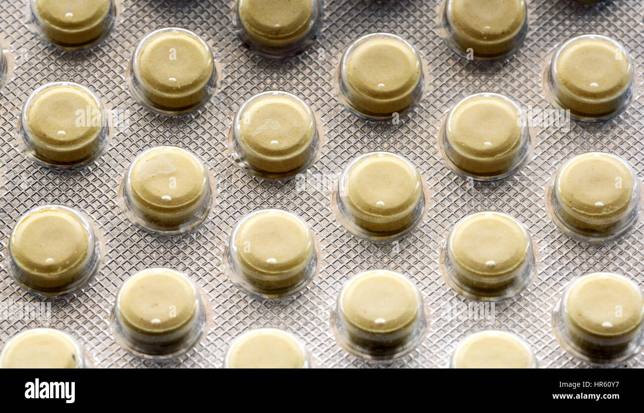 Overhead closeup image of unused yellow medicine tablets still inside ...
