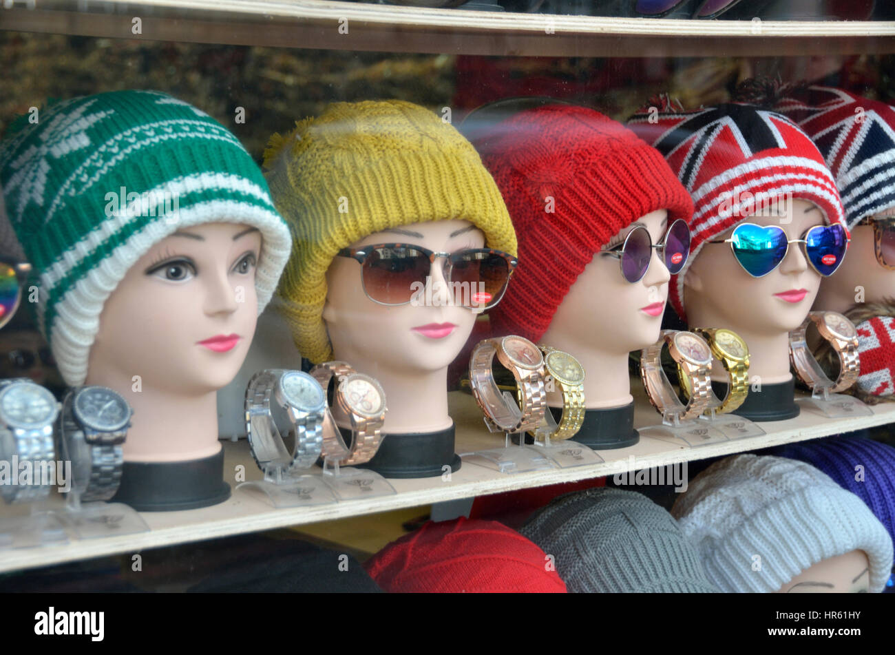 Display of women’s wooly hats on mannequins in a fashion shop window ...