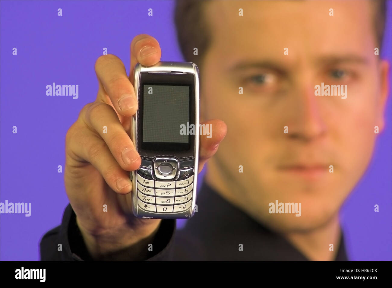 business man holding a mobile phone over a blue background Stock Photo ...
