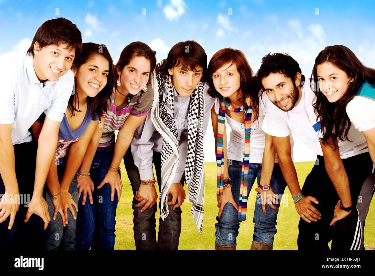 group of happy friends smiling for a portrait in a park with green ...