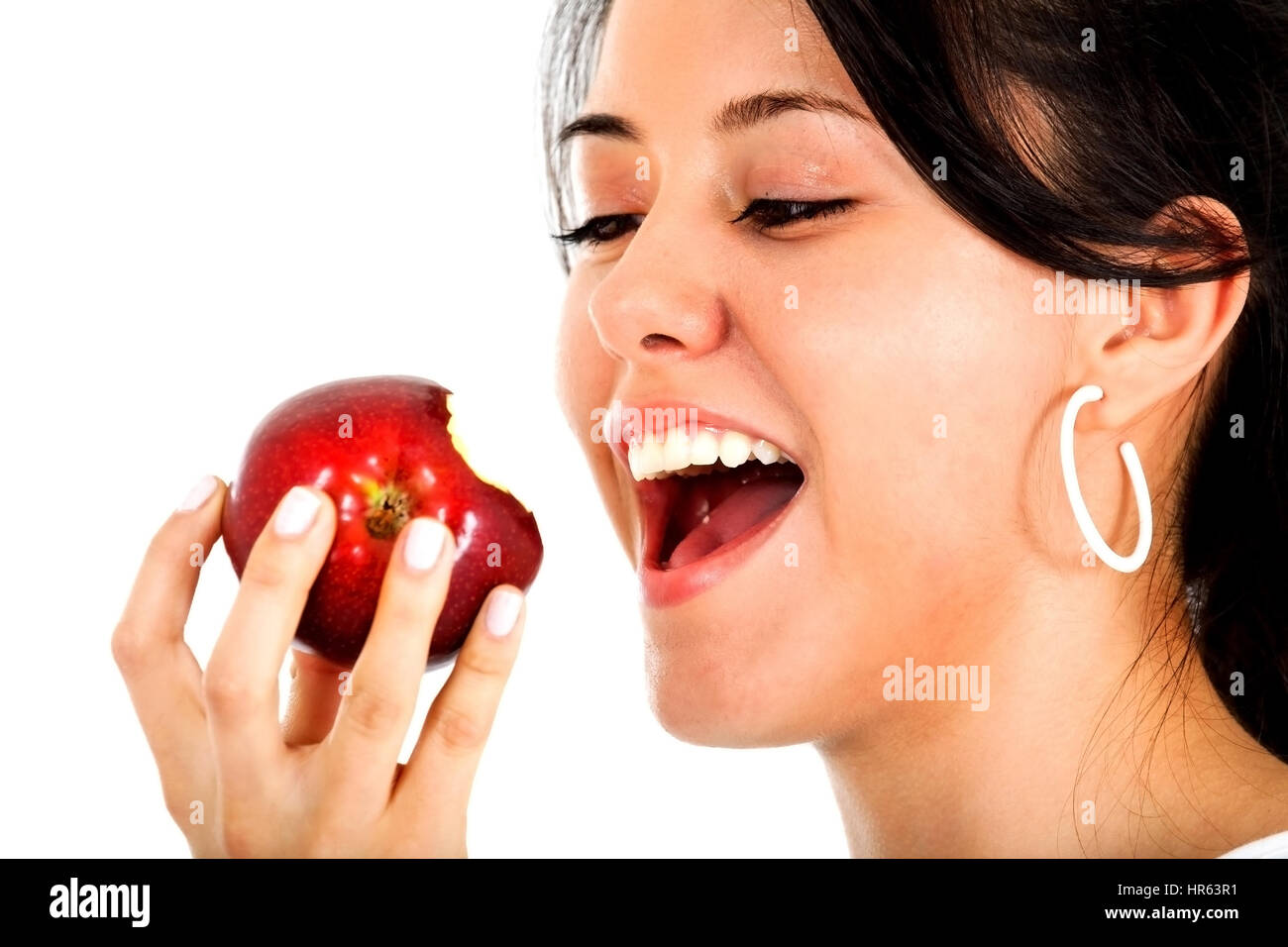 Beautiful casual woman about to bit an apple smiling and isolated over ...
