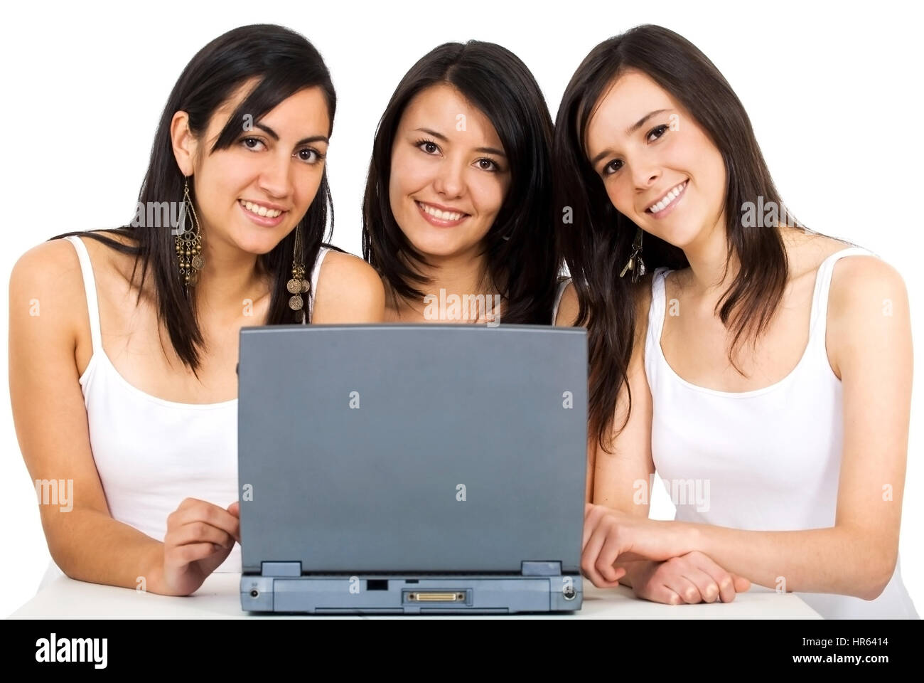 female friends on a laptop computer smiling and isolated over a white ...