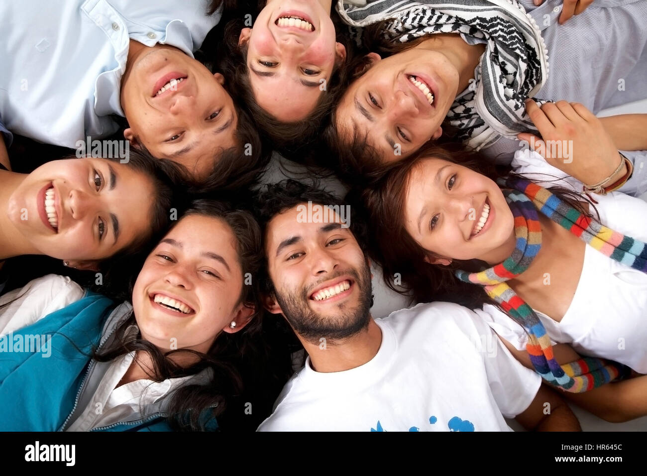 happy group of friends smiling with their heads together on the floor ...