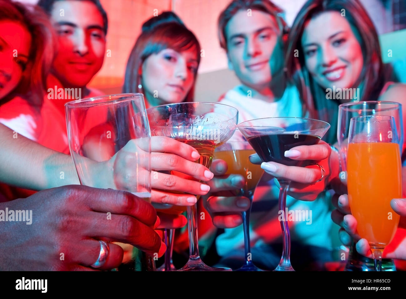 Group of happy friends at a bar or a nightclub toasting Stock Photo - Alamy