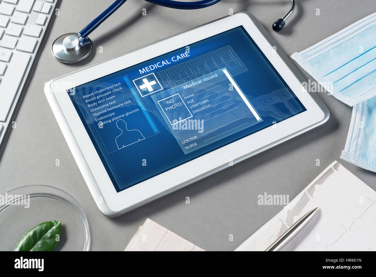 White tablet pc and doctor tools on gray surface Stock Photo - Alamy