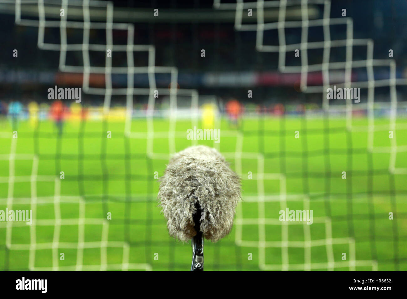 Big and furry sport microphone on a soccer field behind the goal net ...