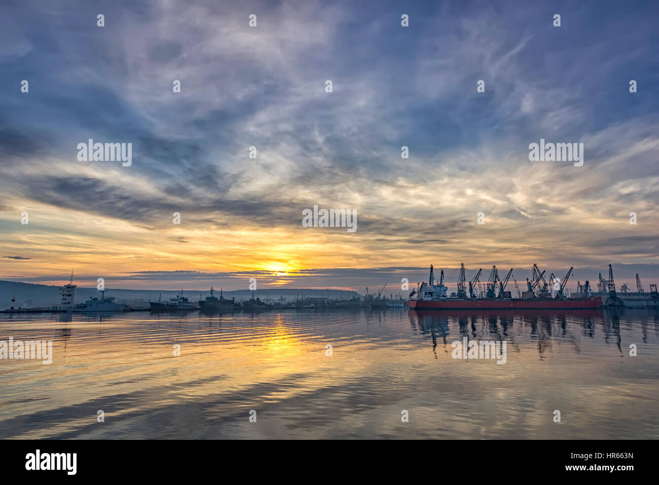 Landscape of ship and cranes in port at sunset Stock Photo - Alamy