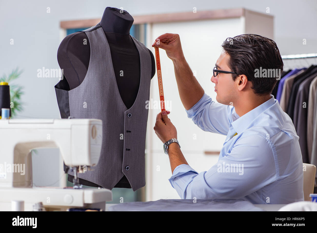 Young man tailor working on new clothing Stock Photo - Alamy