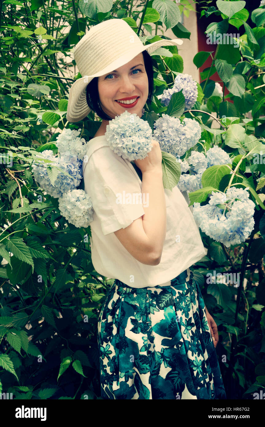 Portrait of a beautiful woman in flower garden Stock Photo - Alamy