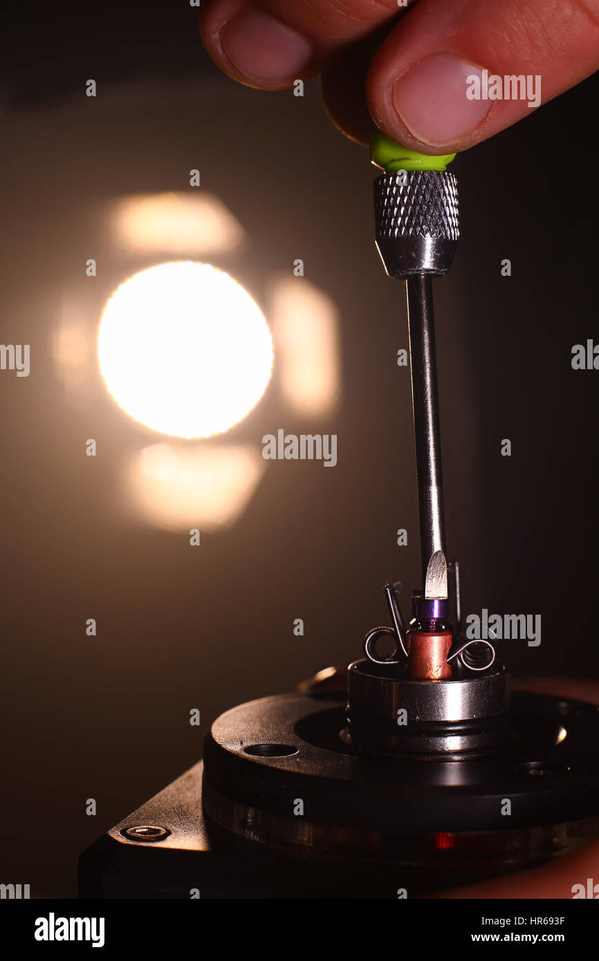 Human hand performing maintenance an electronic cigarette,vaper over ...