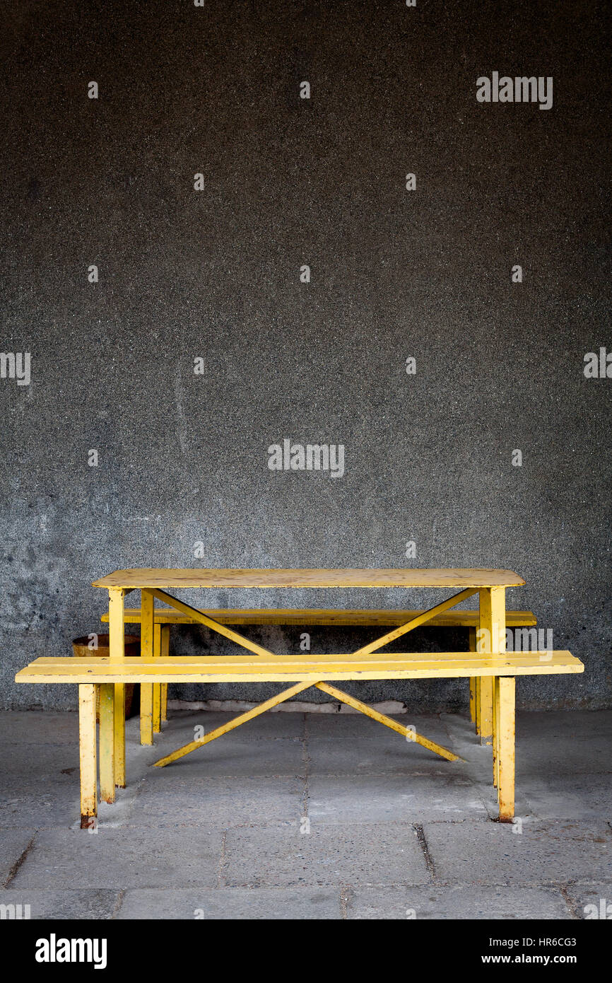 Old wall and yellow rusty table with a bench Stock Photo - Alamy