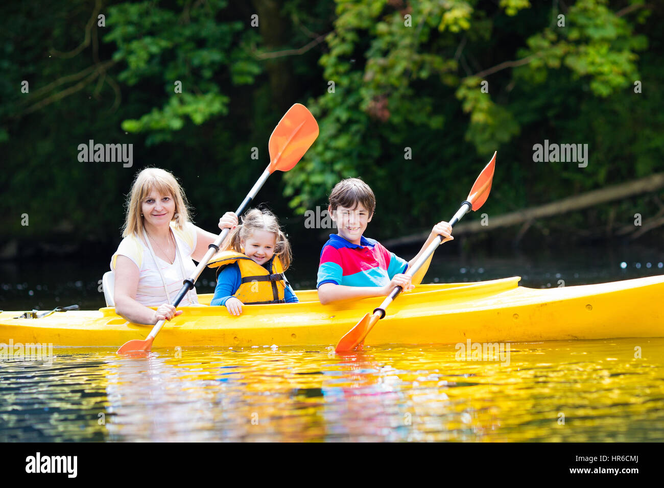 Happy family with two kids enjoying kayak ride on beautiful river ...