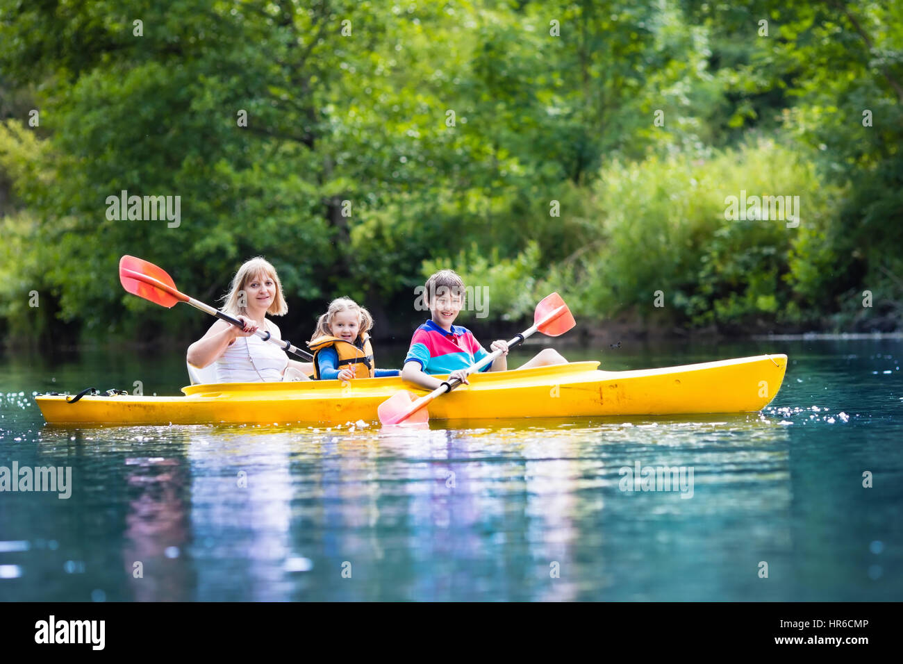 Happy family with two kids enjoying kayak ride on beautiful river ...