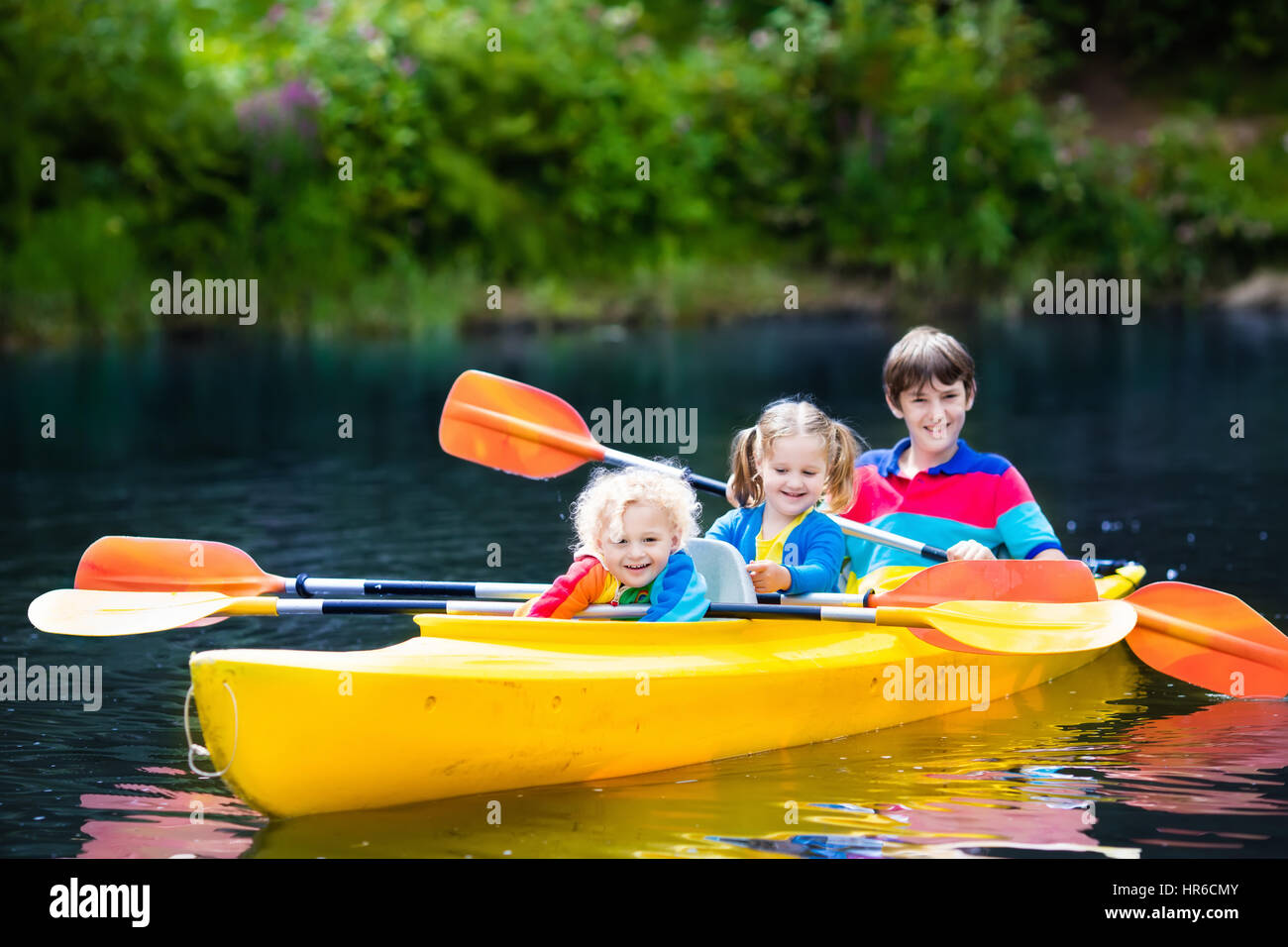 Happy family with three kids enjoying kayak ride on beautiful river ...