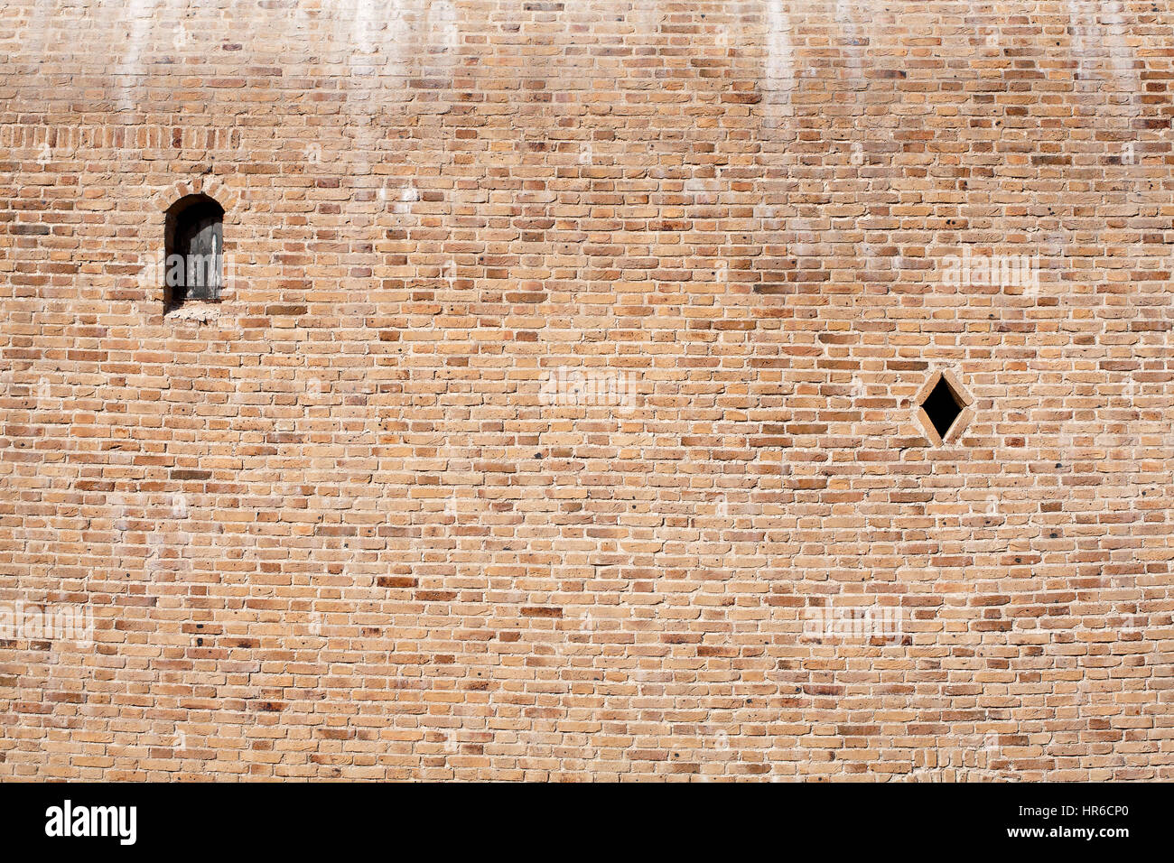 Brick wall with two small windows Stock Photo - Alamy